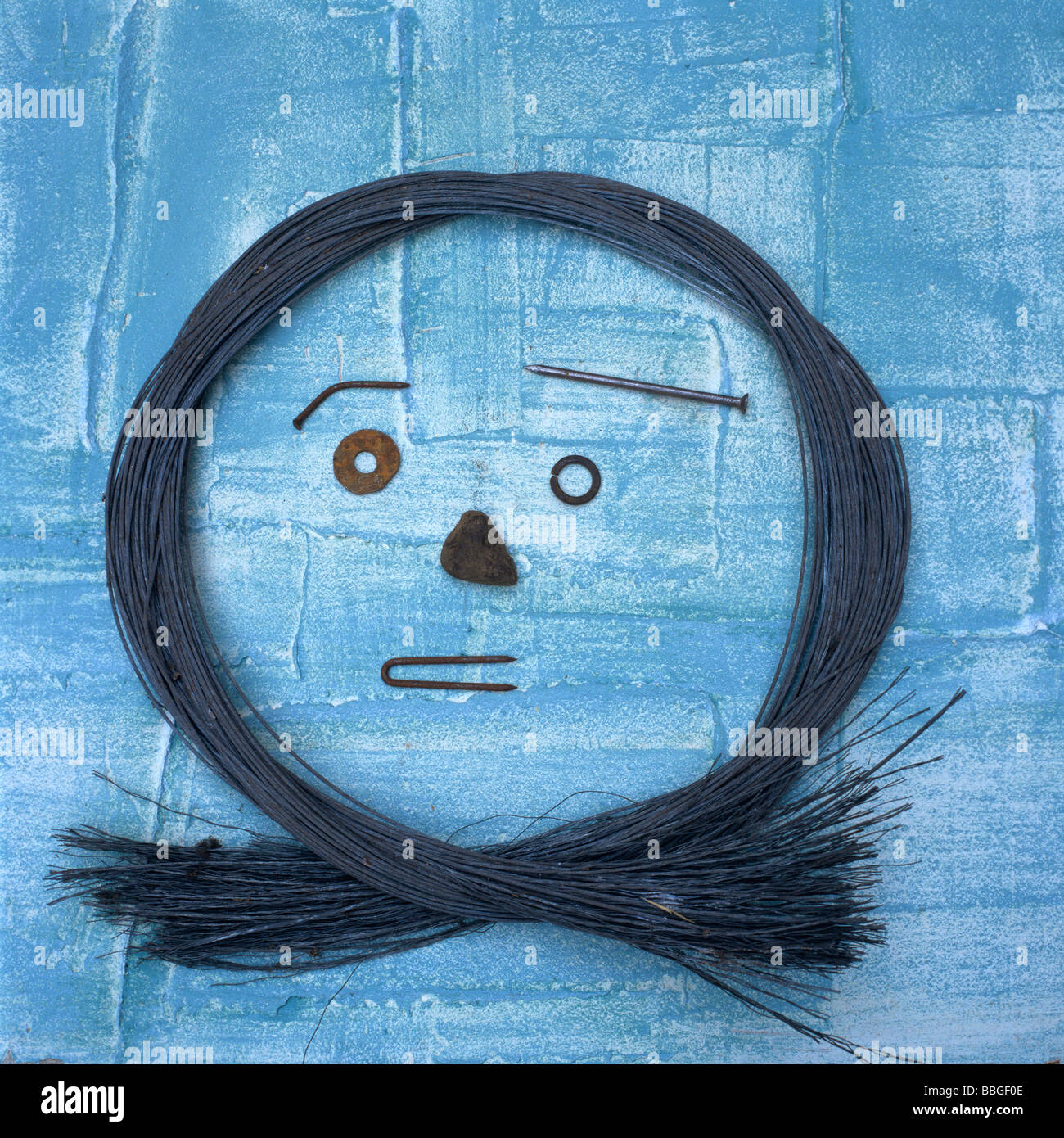 Creative arrangement of wires and objects creating a face on a blue ...