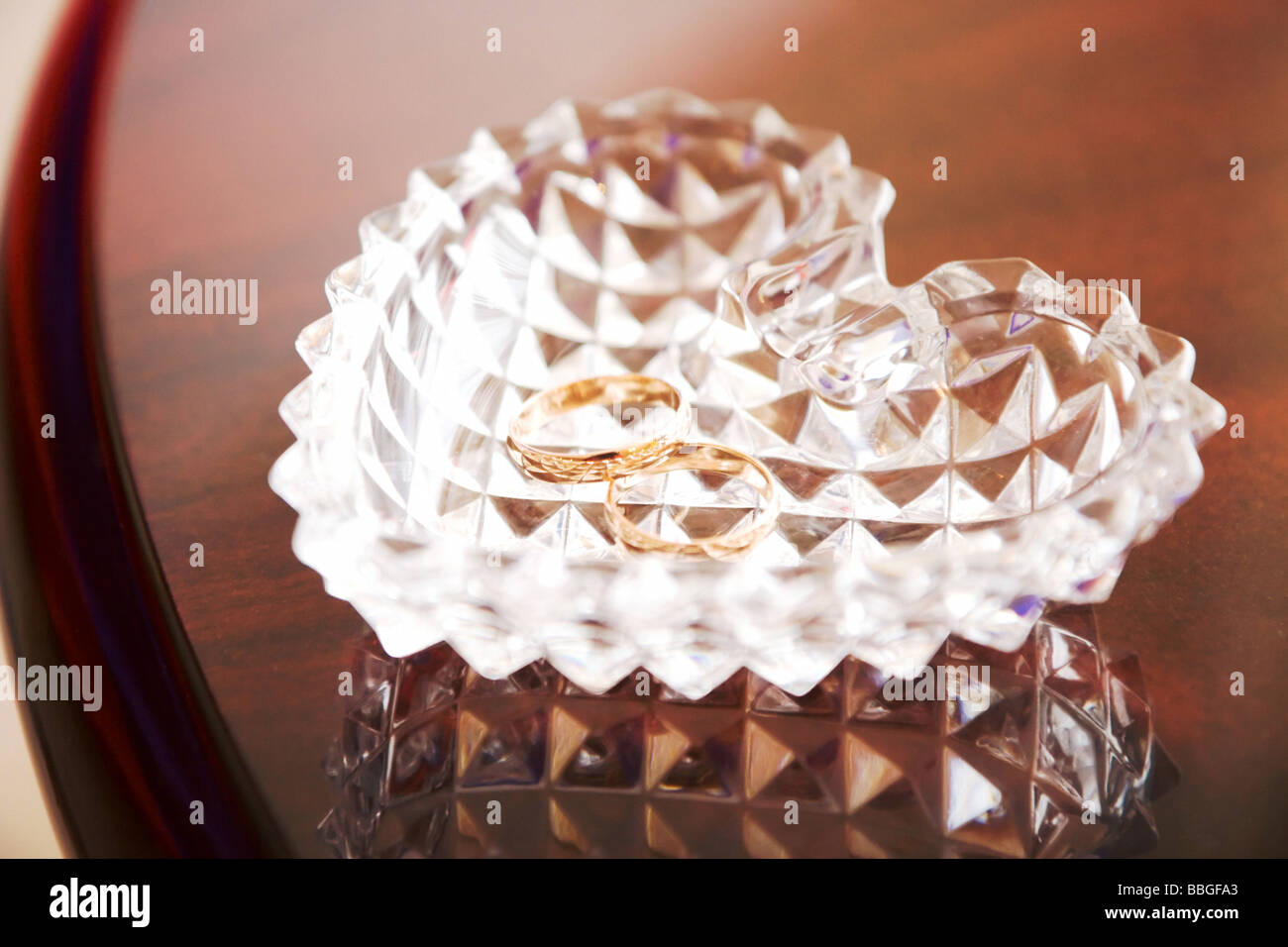 Close up of a wedding rings on cut glass plate Stock Photo - Alamy
