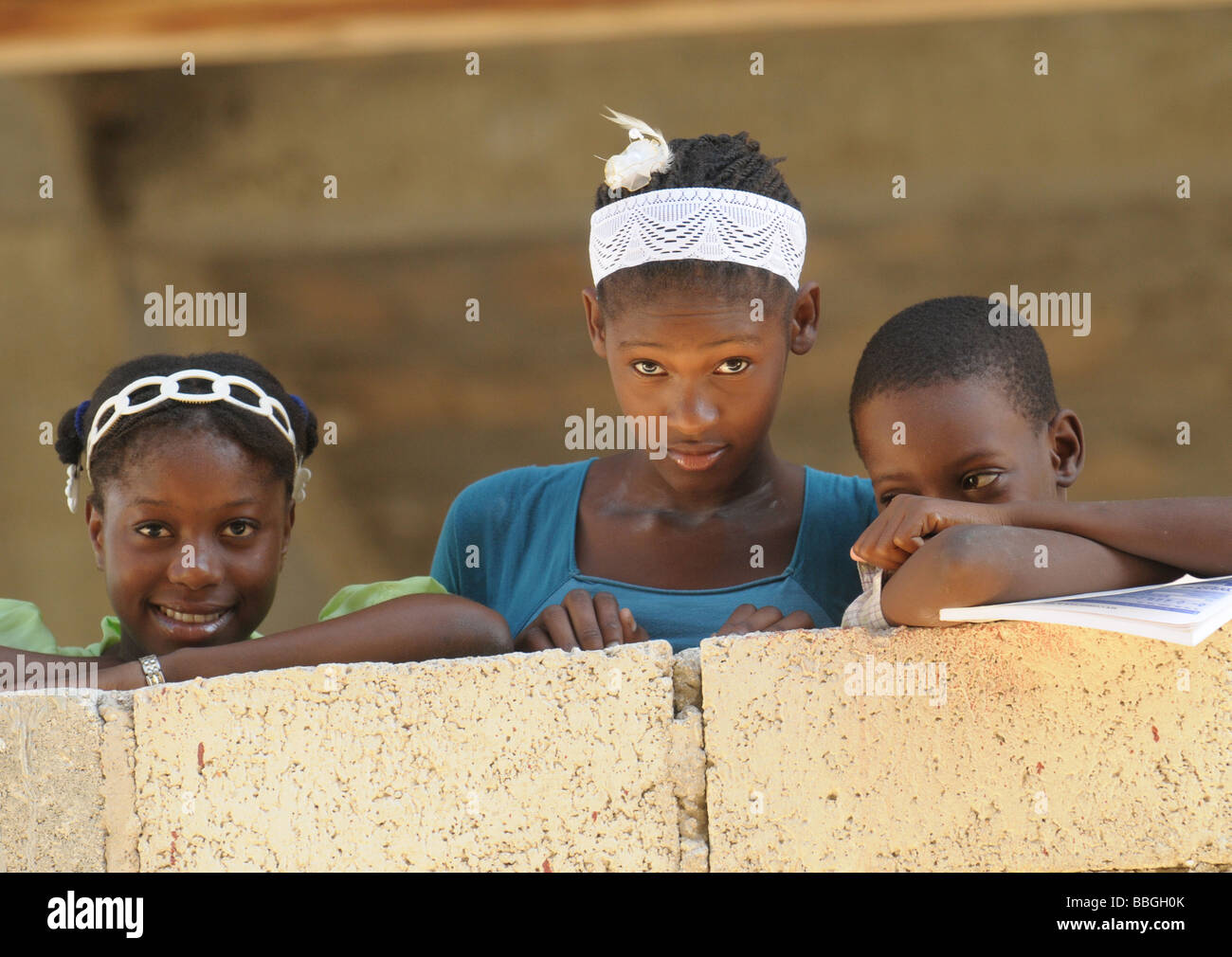 Three young black children leaning on a wall Stock Photo - Alamy