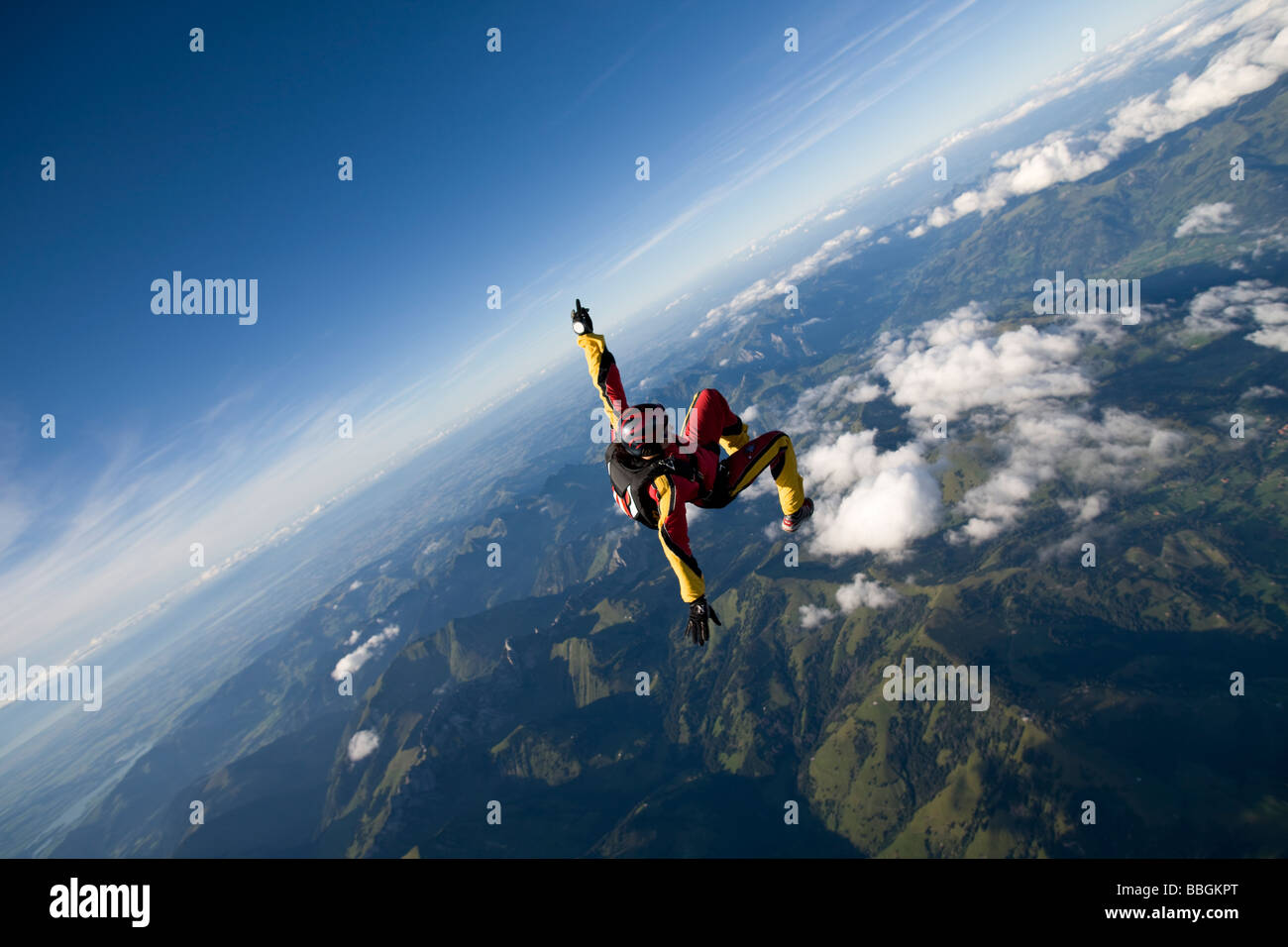 Skydiver is flying over a spectacularly mountain scenery and clouds ...