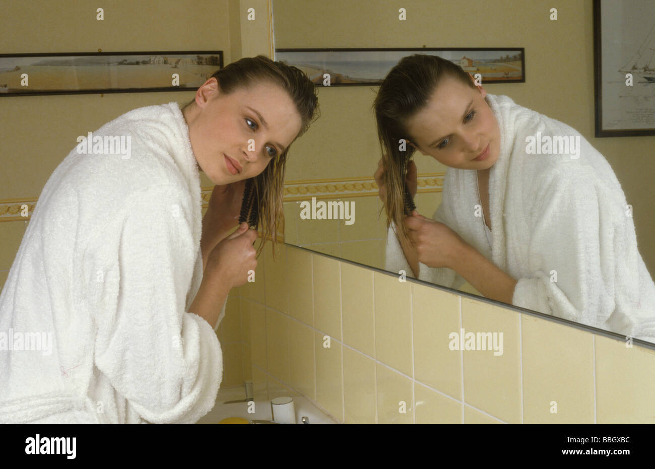 blonde woman disentangling her long wet hair over a basin Stock Photo ...