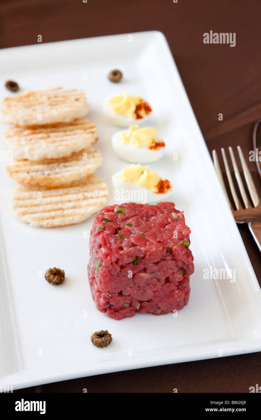 Exotic entree of bison tartare herbed potato bread deviled quail s eggs ...
