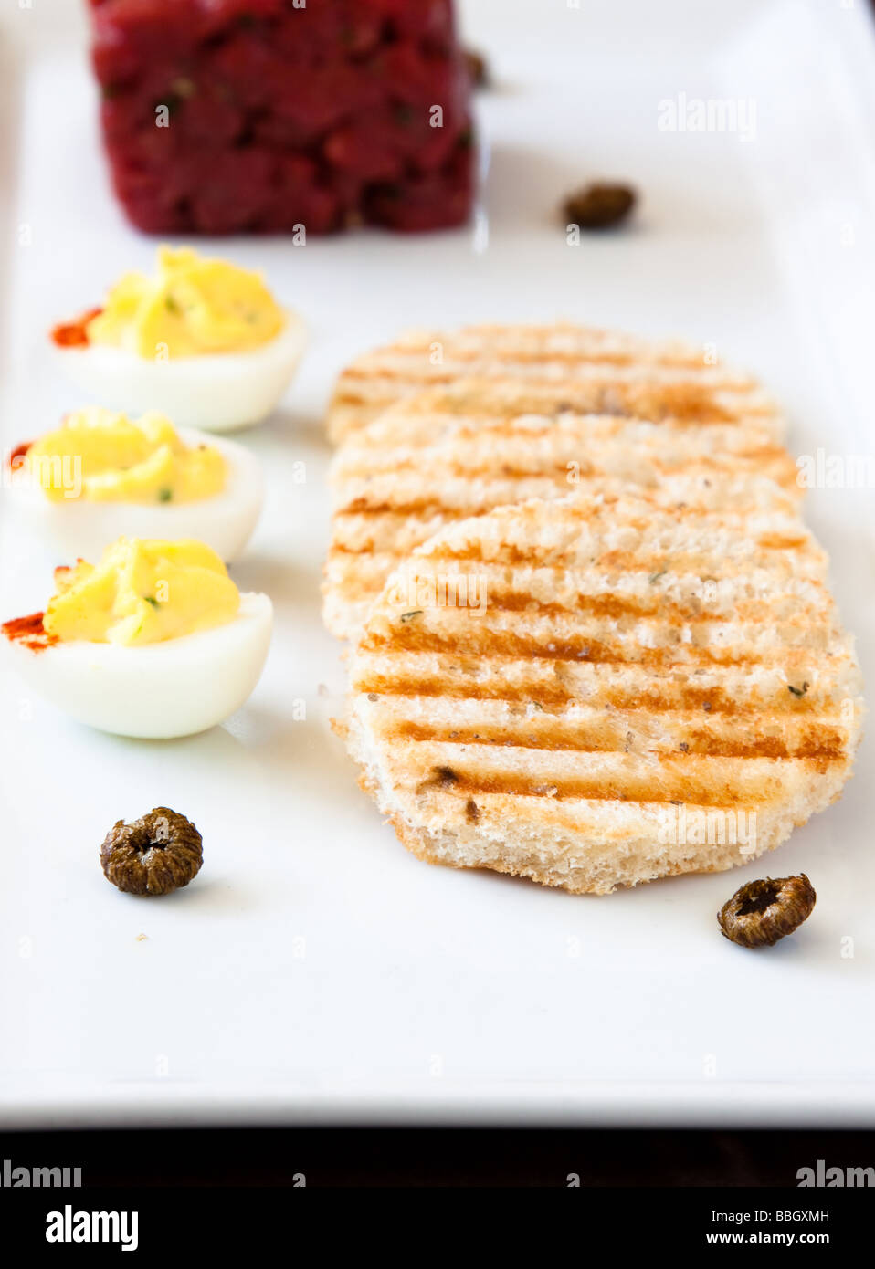 Exotic entree of bison tartare herbed potato bread deviled quail s eggs ...