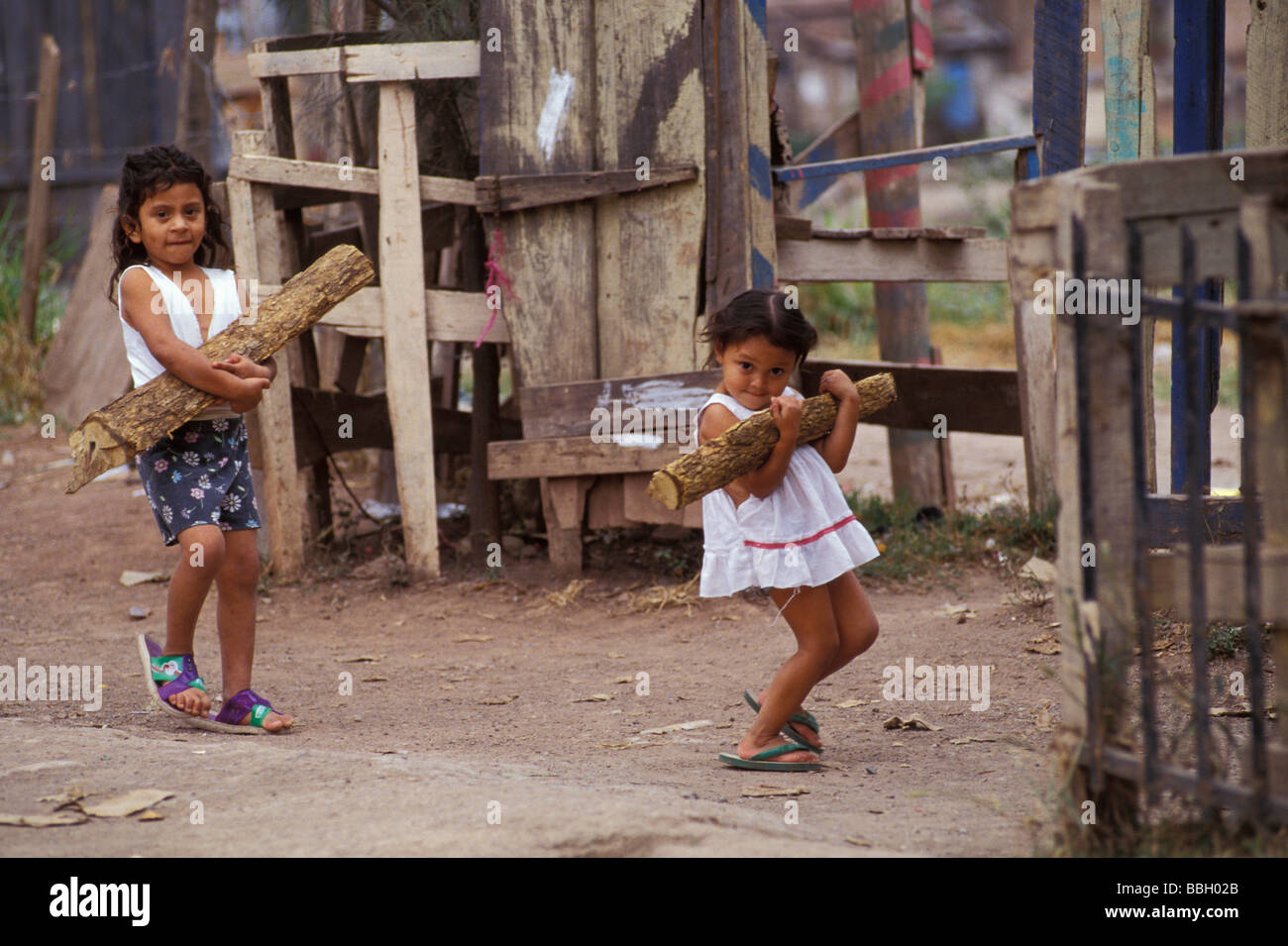 Two children carry wood Stock Photo - Alamy