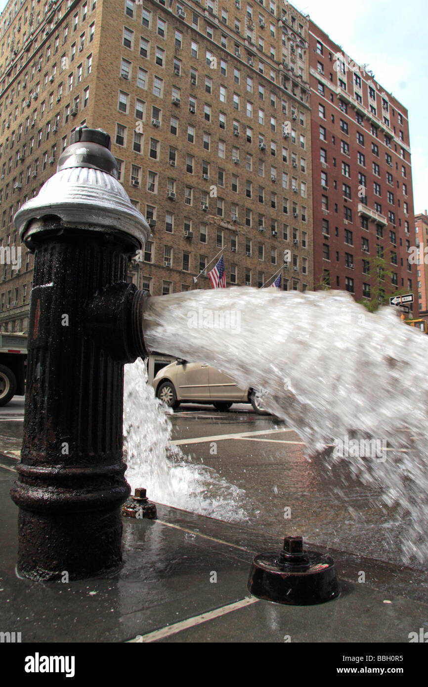 An open fire hydrant flooding the road on Fifth Avenue, New York Stock ...