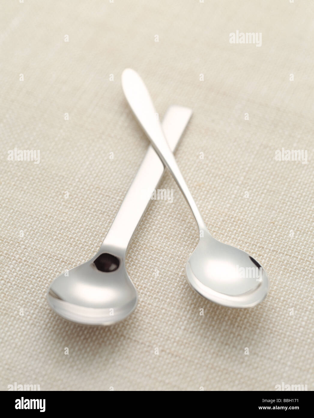 Two silver spoons on a linen brown background Stock Photo - Alamy