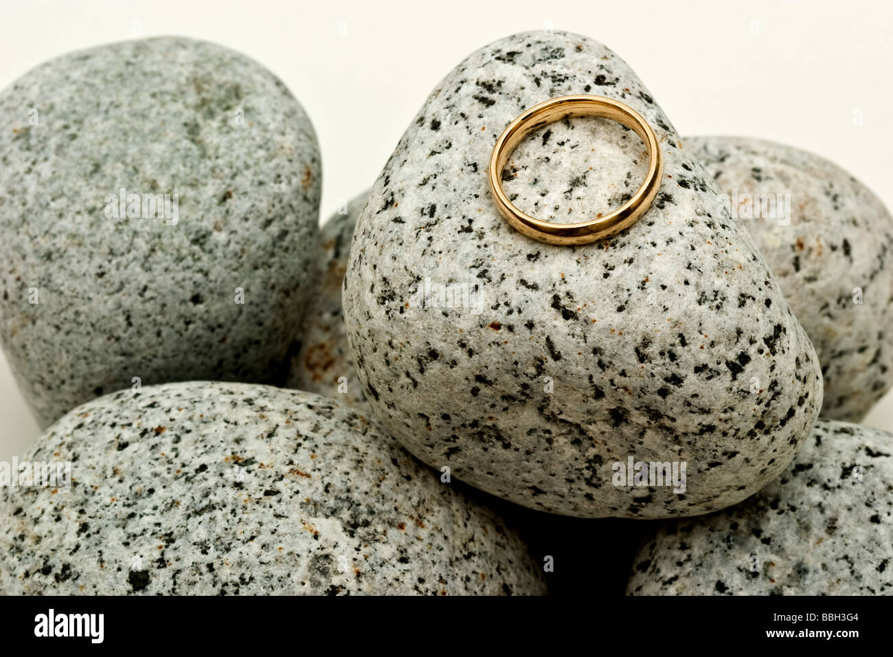 Man's wedding band on a pile of white granite rocks Stock Photo - Alamy