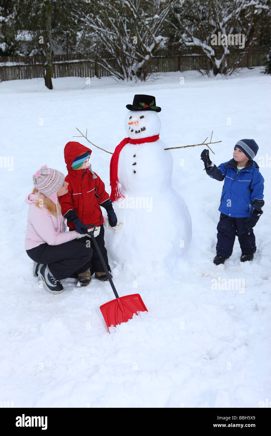 Family making a snowman Stock Photo - Alamy