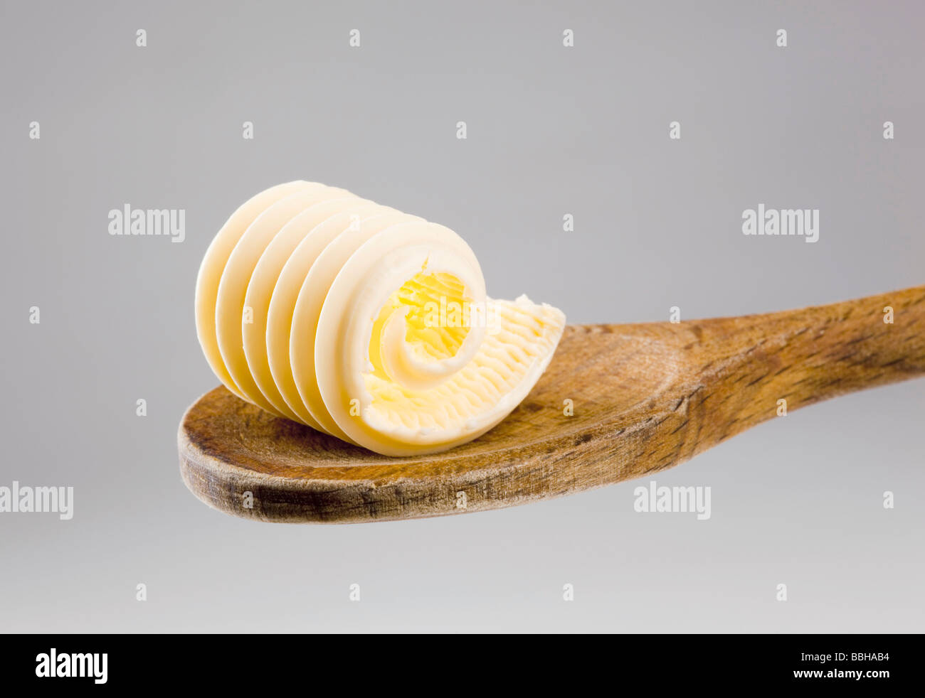 Butter curl on a wooden spoon Stock Photo - Alamy