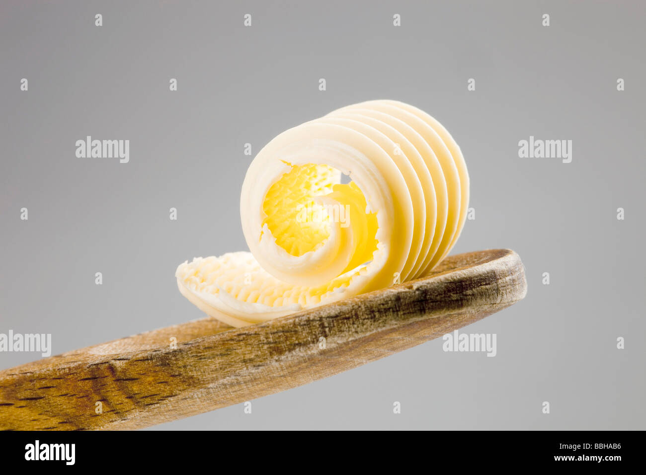 Butter curl on a wooden spoon Stock Photo - Alamy