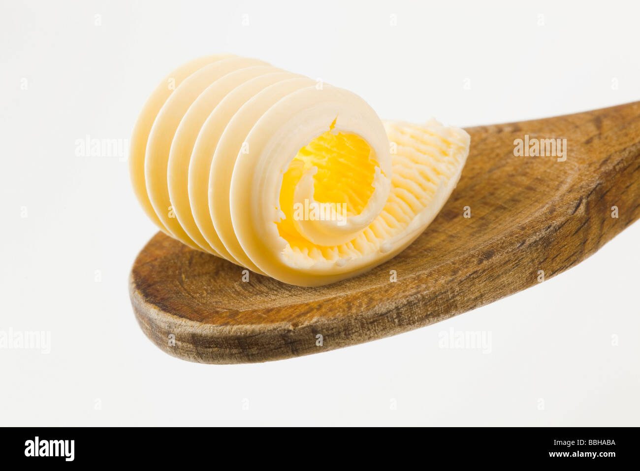 Butter curl on a wooden spoon Stock Photo - Alamy
