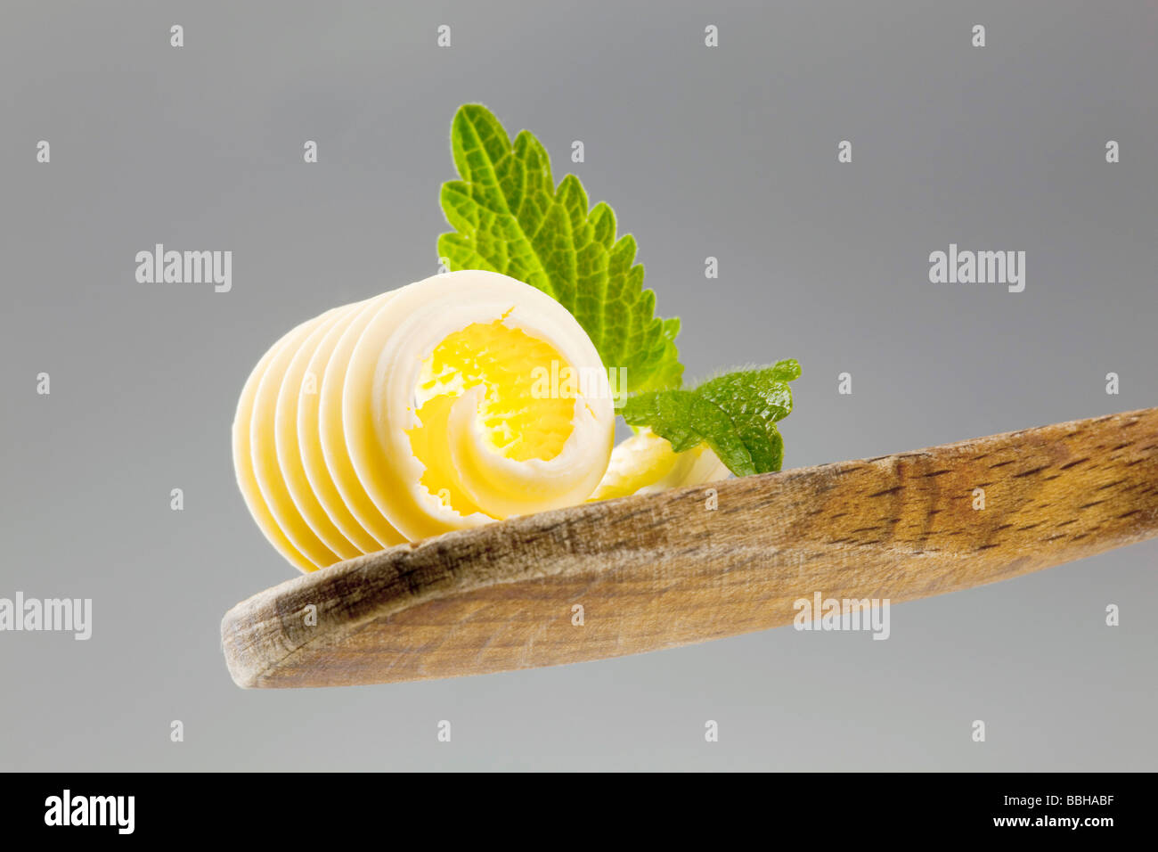 Butter curl on a wooden spoon Stock Photo - Alamy