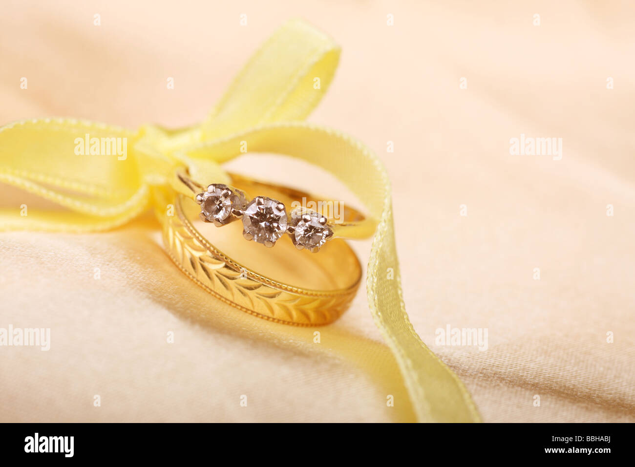 gold wedding and diamond engagement ring with yellow ribbon Stock Photo ...