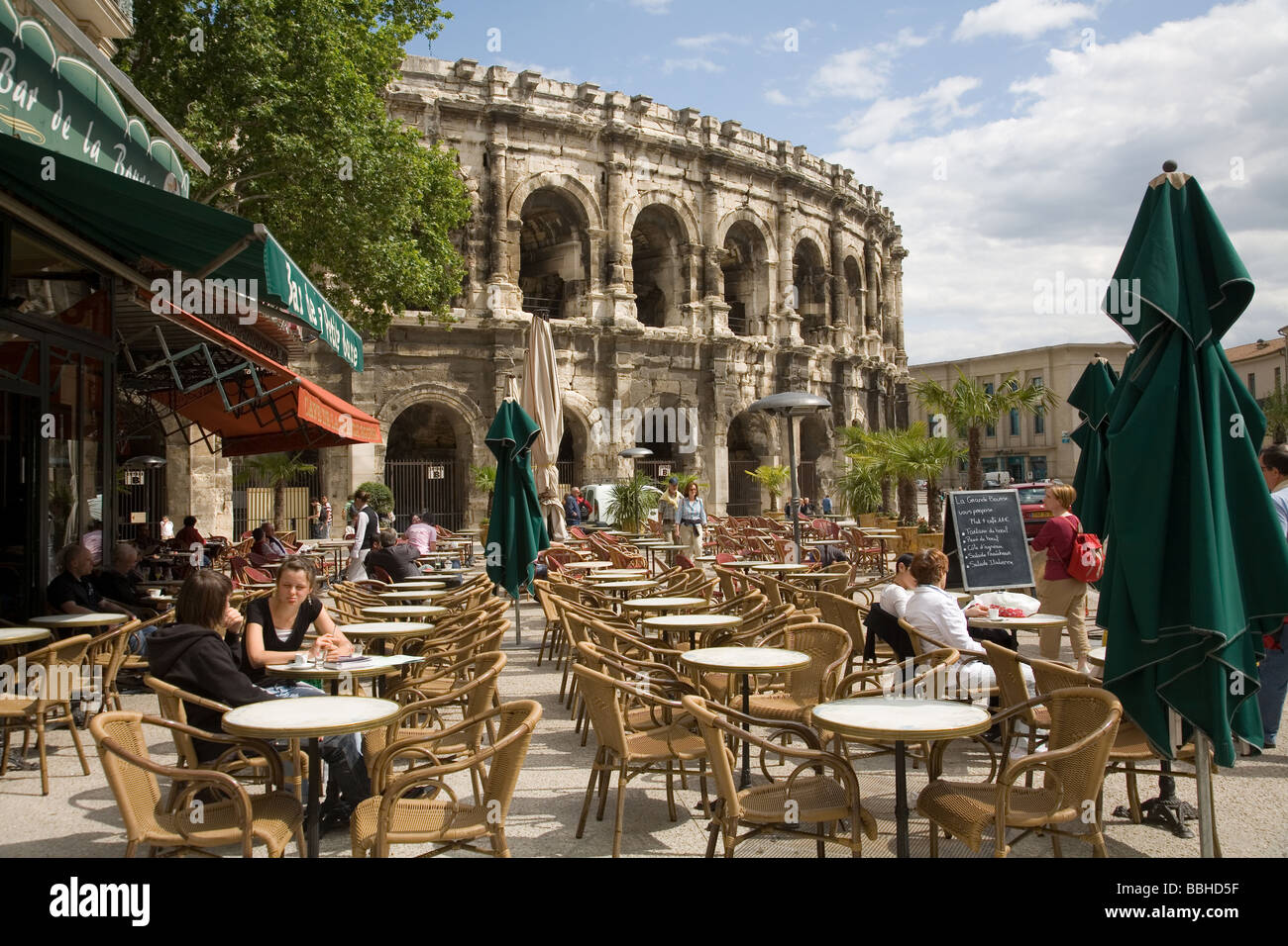 An outdoor cafe alongside the Roman amphitheatre of Les Arenes in Nimes ...