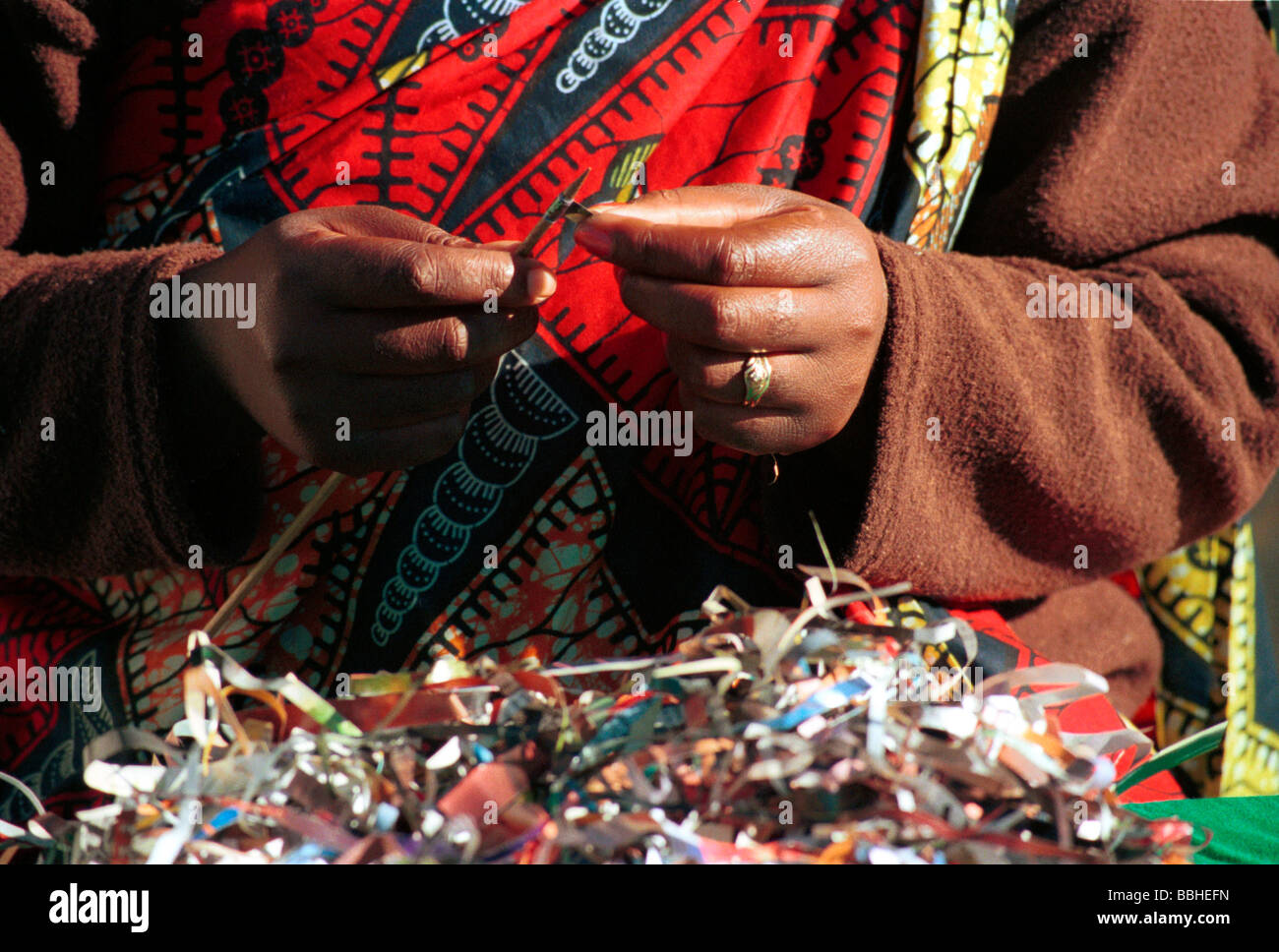 A Rwandan worker creates colourful beads from paper at Umtha Beads a ...
