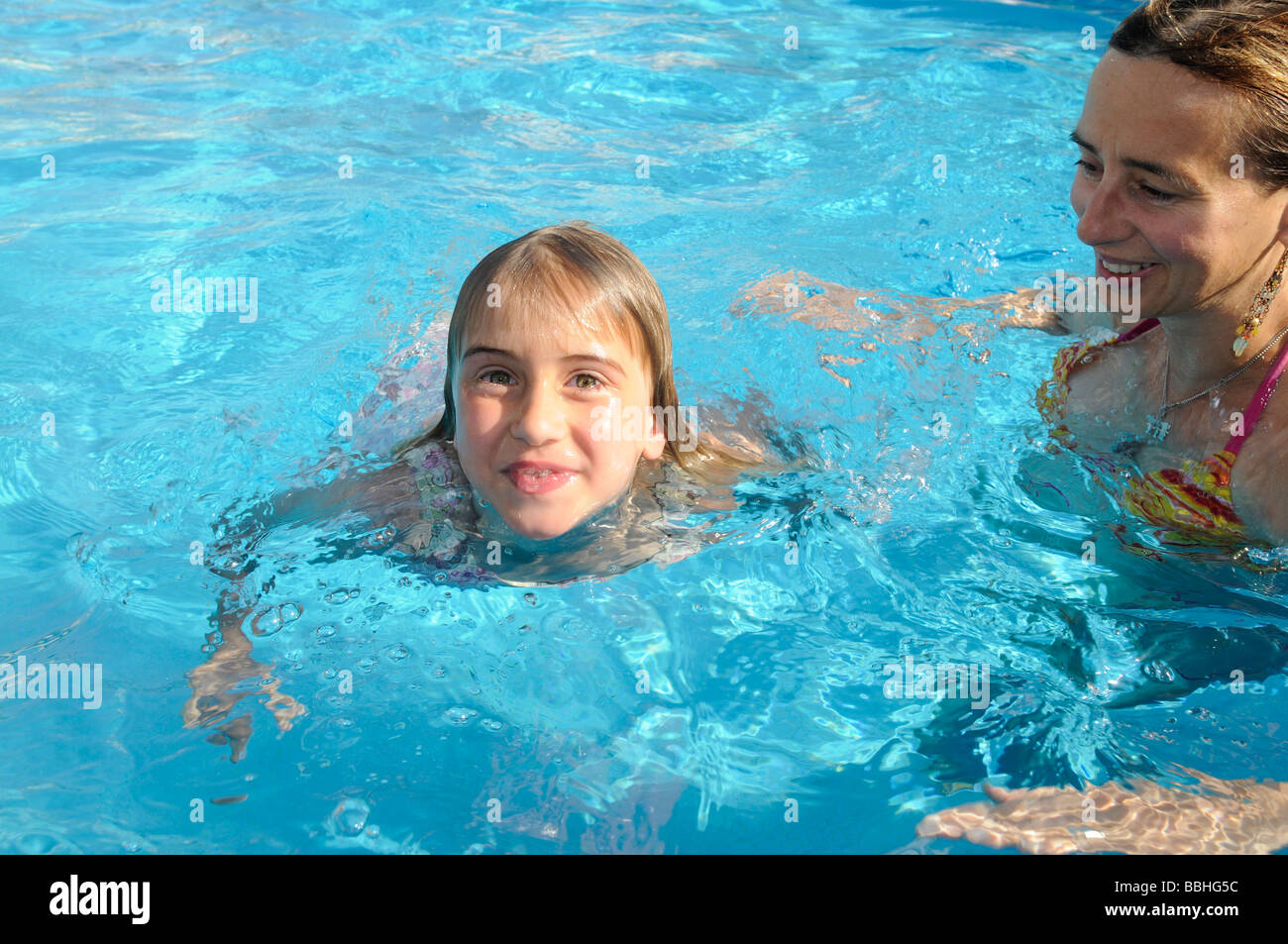 A mother teaches her young daughter to swim Stock Photo - Alamy