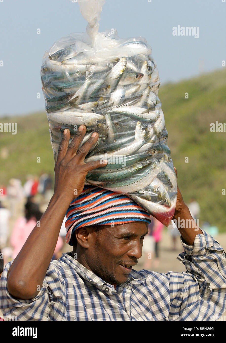 A man assists others buyers to carry the sardines to help them to their ...
