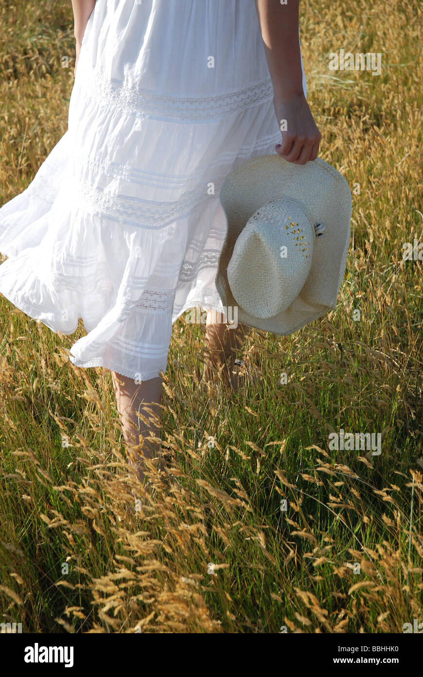 A woman walking through a meadow Stock Photo - Alamy