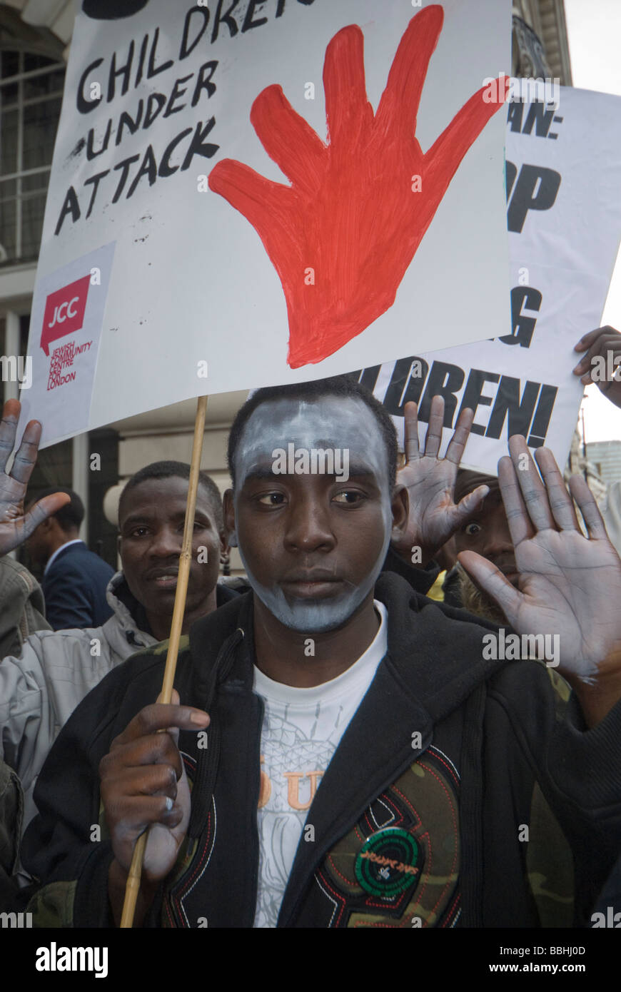 Red hand on placard and white painted hands raised by black men in ...