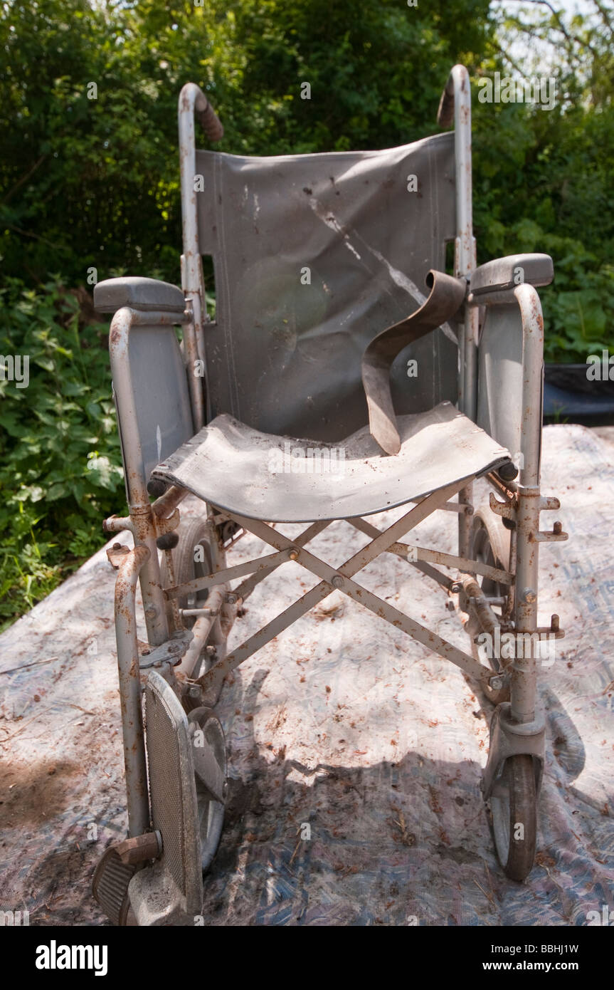 Abandoned wheelchair on an old mattress covered in dirt and rust Stock ...