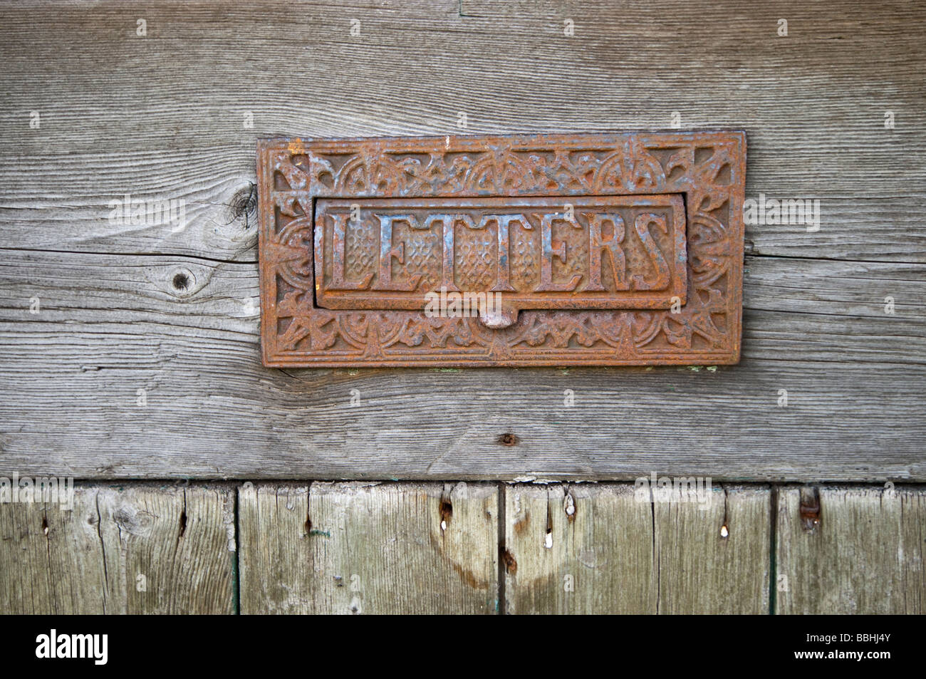 Old cast iron metal letterbox with rust, on a weathered door Stock ...