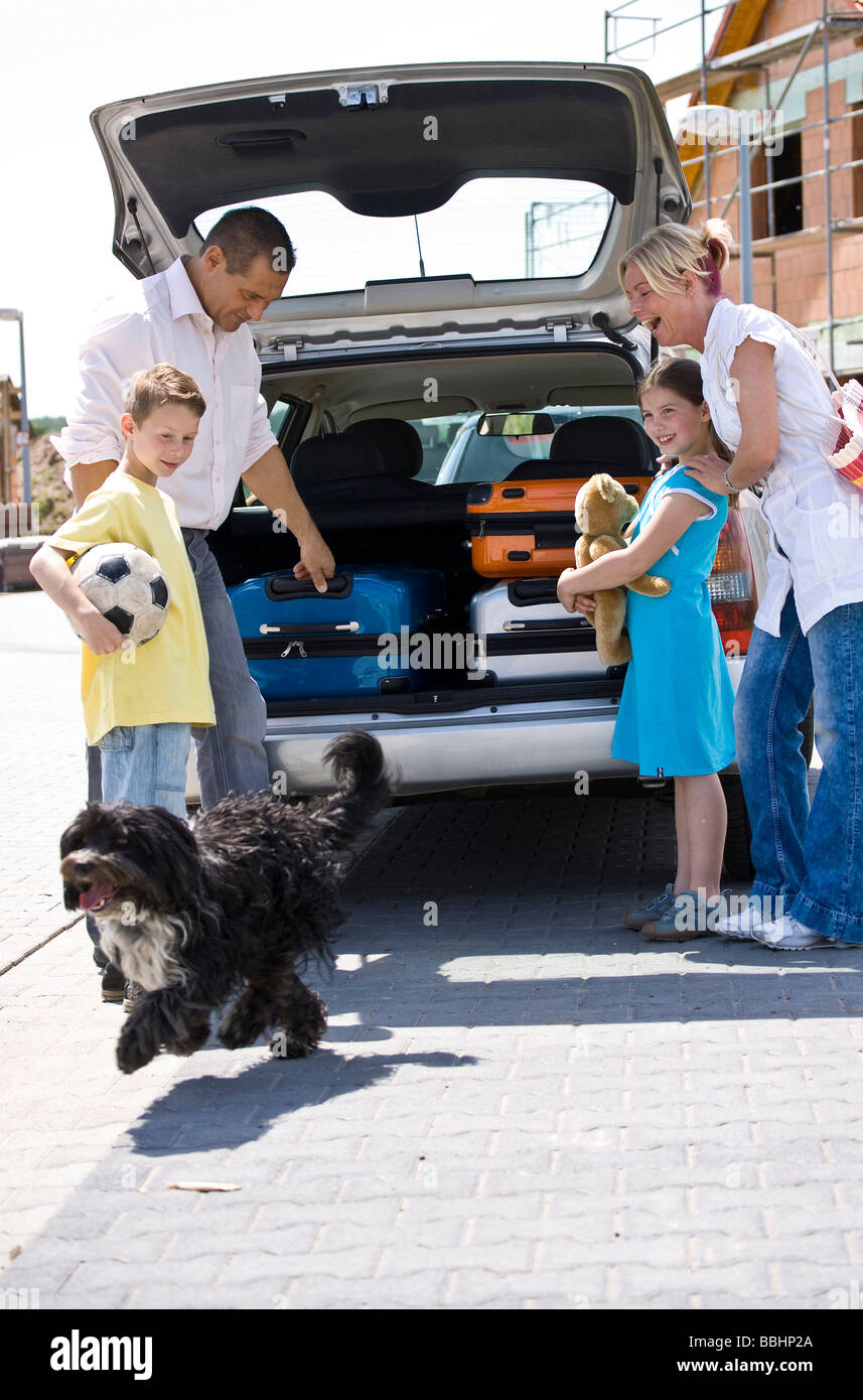 Family stowing the suitcases in the car Stock Photo - Alamy