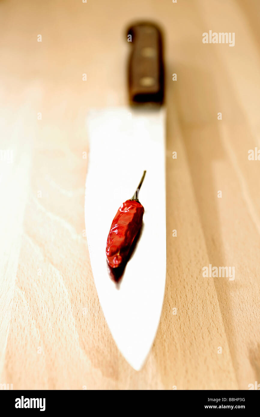 Red Chili on blade of large kitchen knife, studio Stock Photo - Alamy