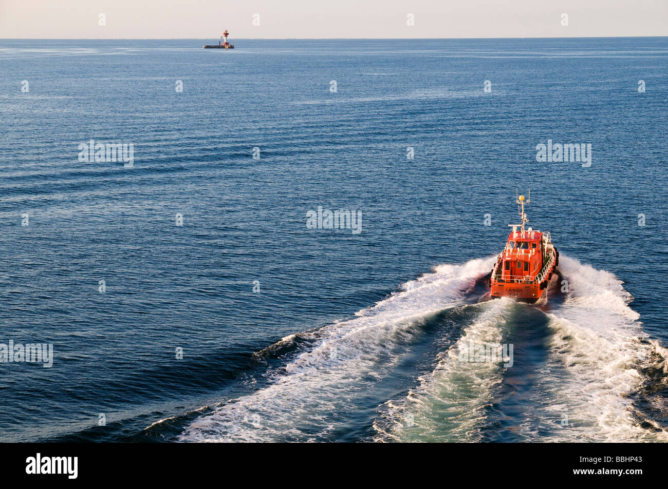 Pilot boat and lighthouse Stock Photo - Alamy