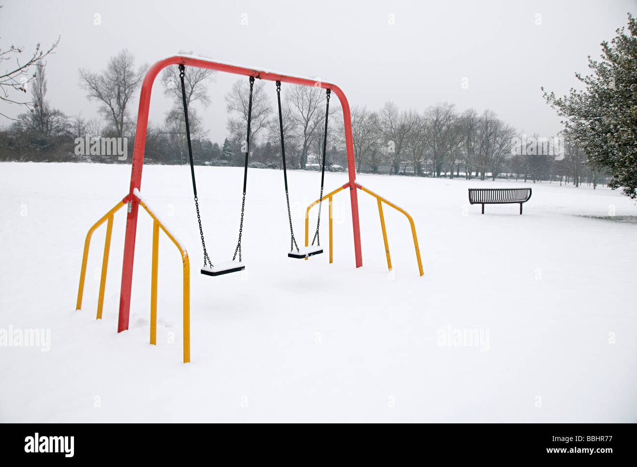 a swing covered with snow on a snowy day in a childrens playground in ...