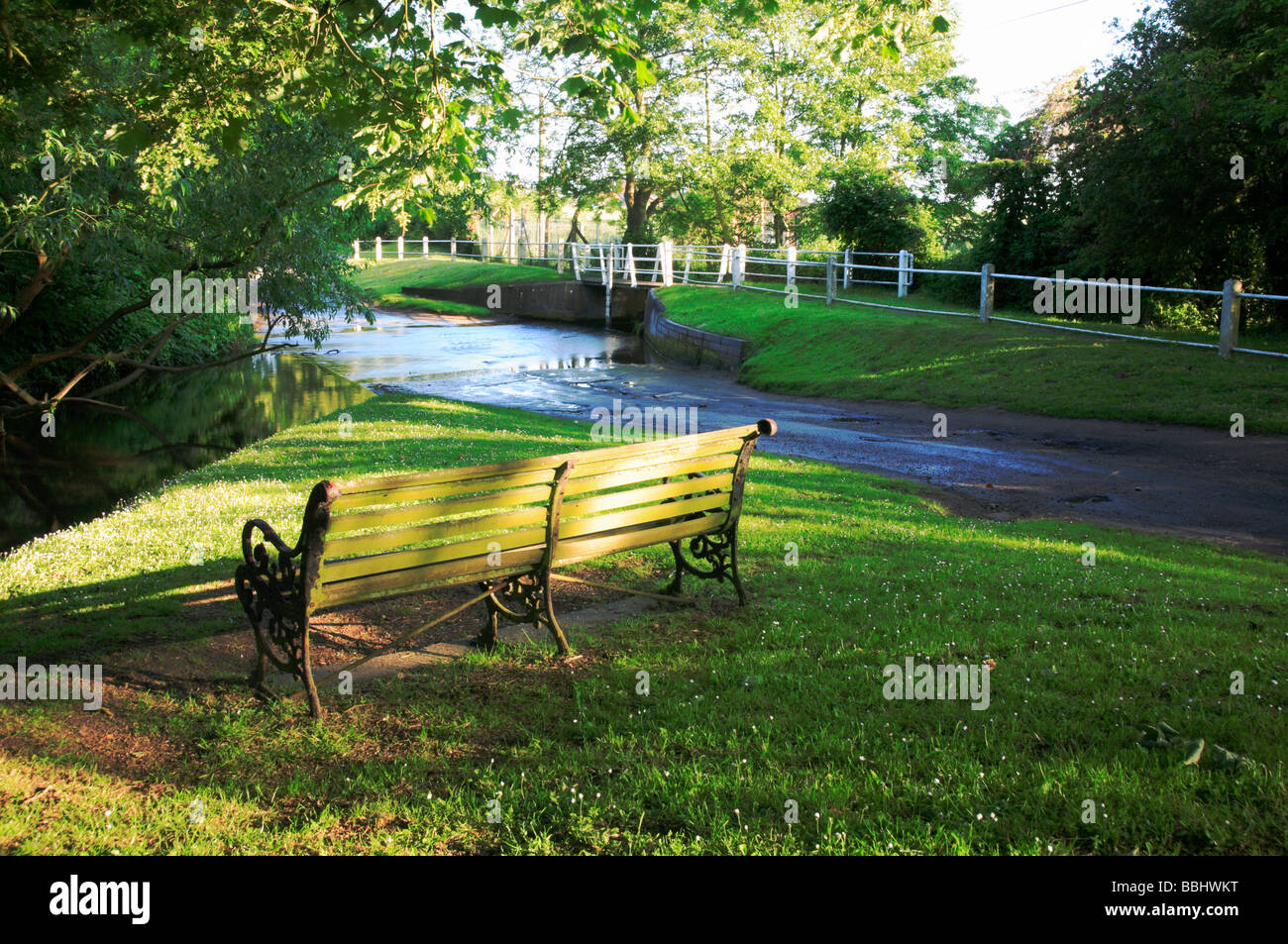 Seat by a ford and pedestrian footbridge over the River Stiffkey at ...