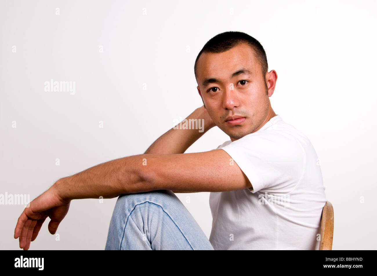 earnest relaxed pose of a young man on a chair Stock Photo - Alamy