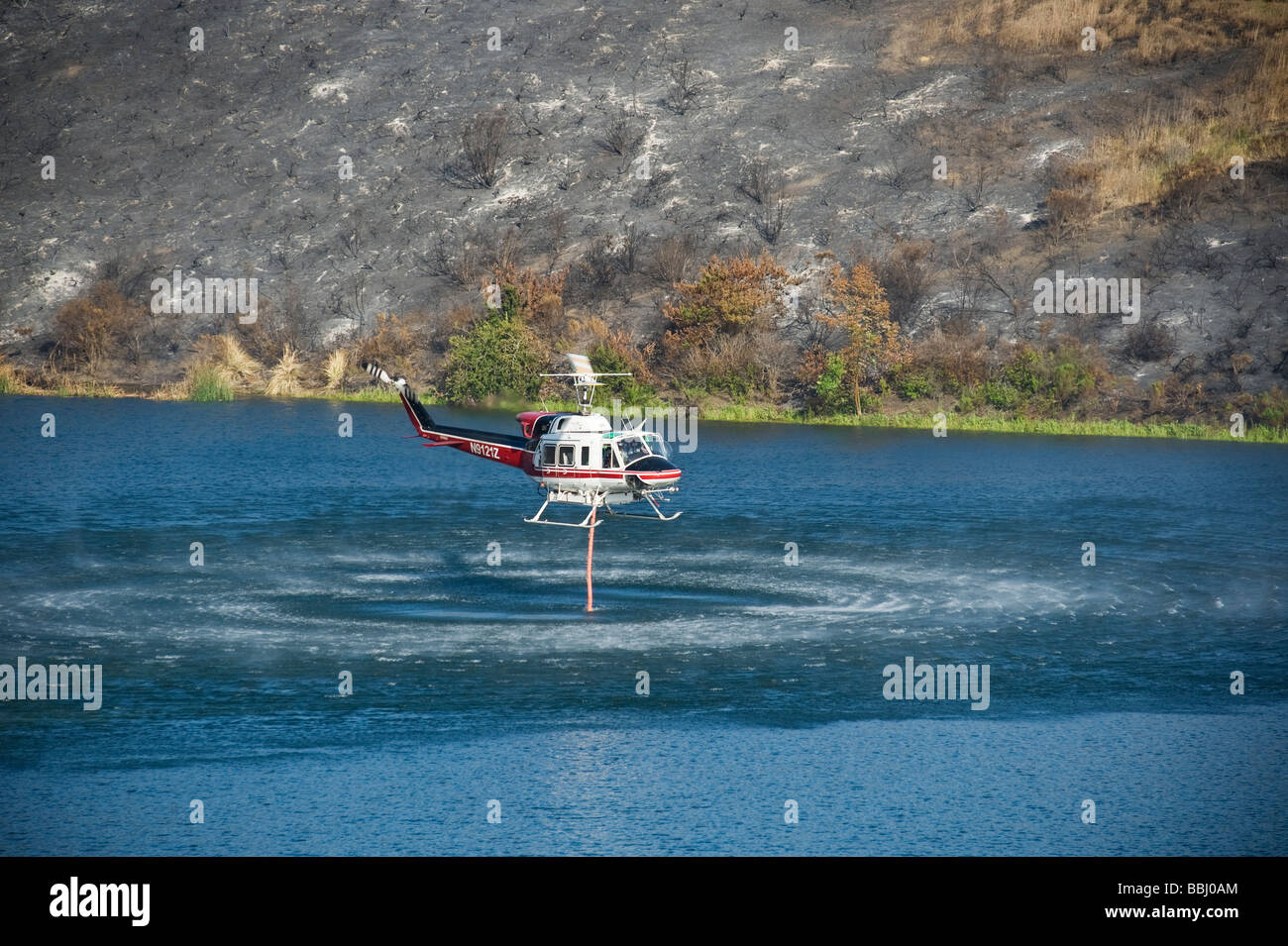 FIre fighting helicopter takes on water from Lauro Reservior during ...