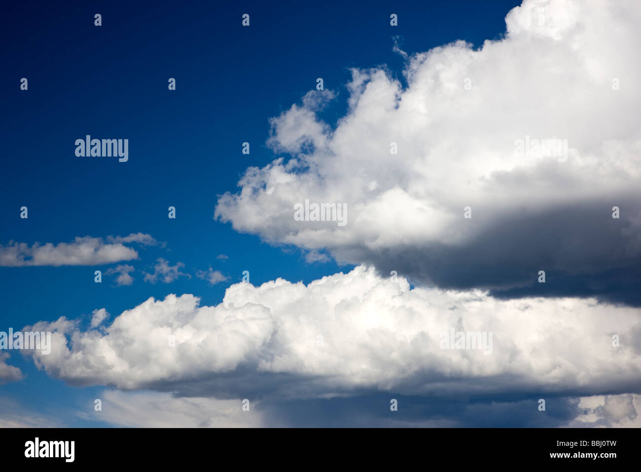 Puffy white cumulous clouds against a clear blue sky between Gunnison ...