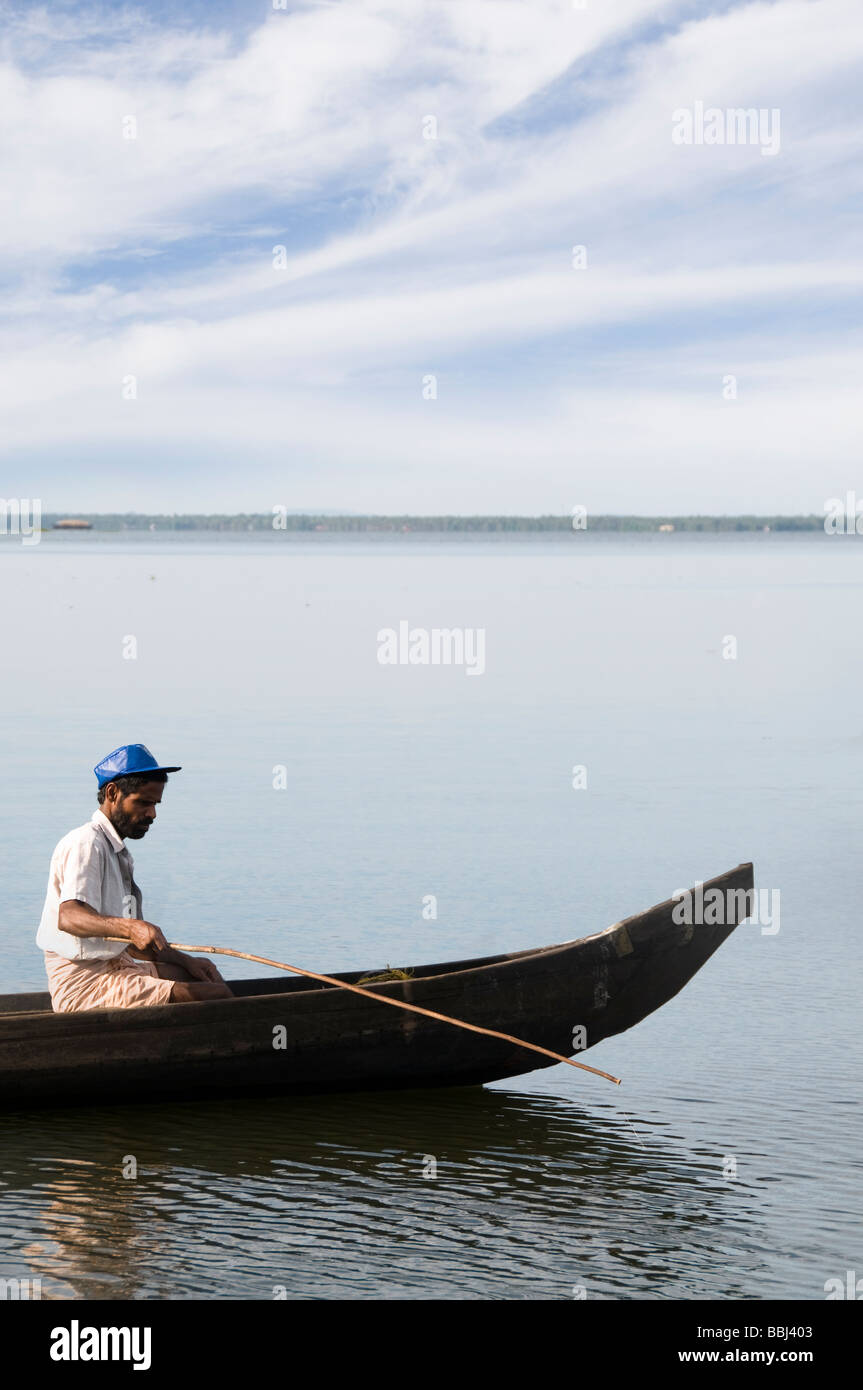 Indian fisherman in rowing boat fishing on lake, backwaters kerala ...