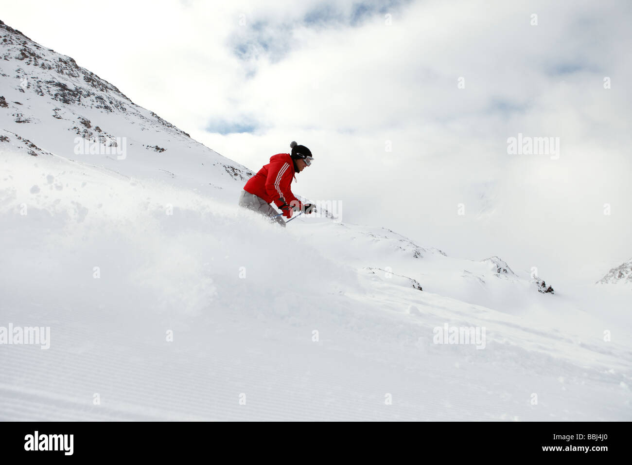 Skier enjoys the fresh snow on the edge of the piste, ski resort of Les ...