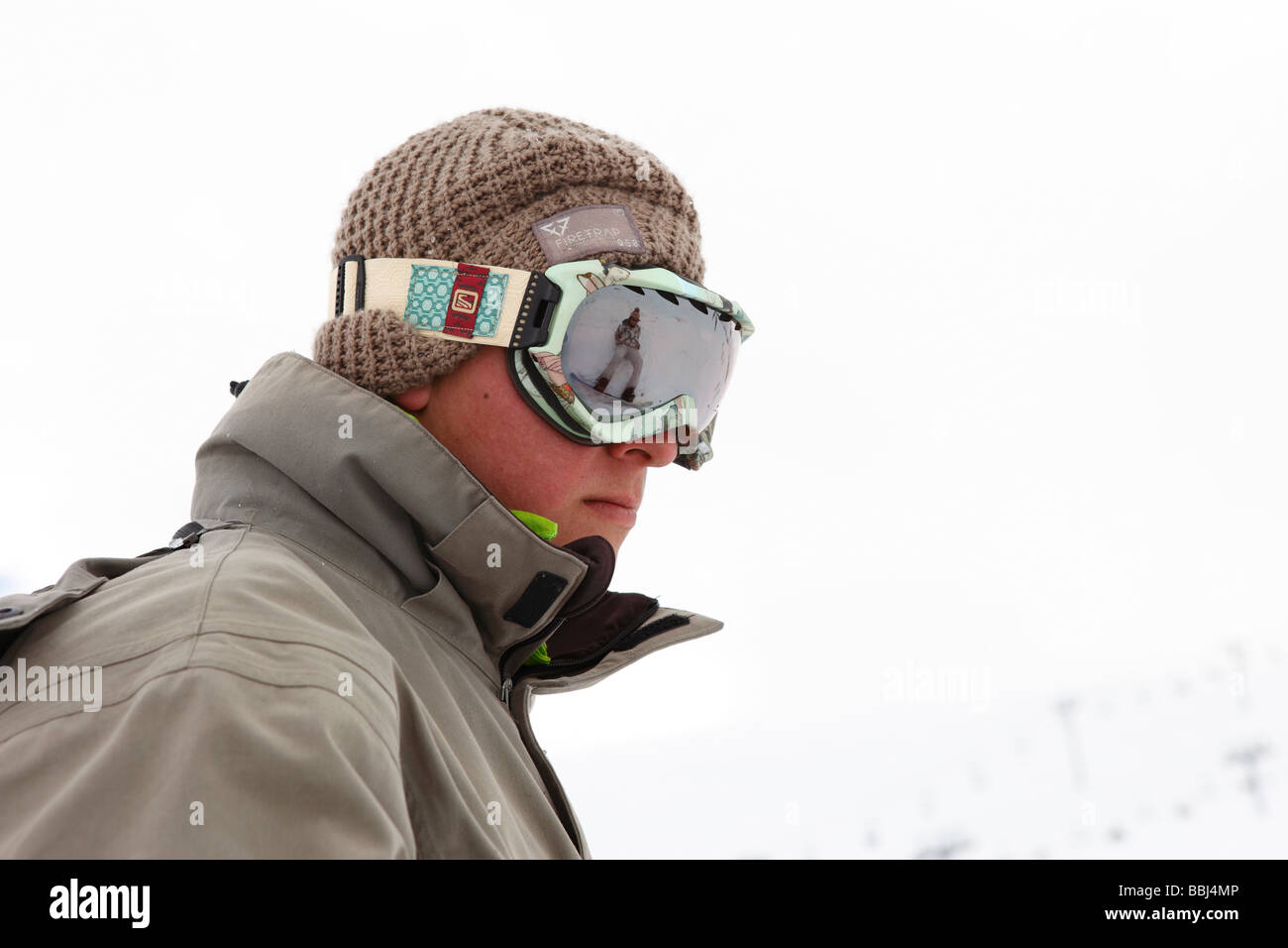 Snowboarder seen in the reflection of his friends goggles in the ski ...