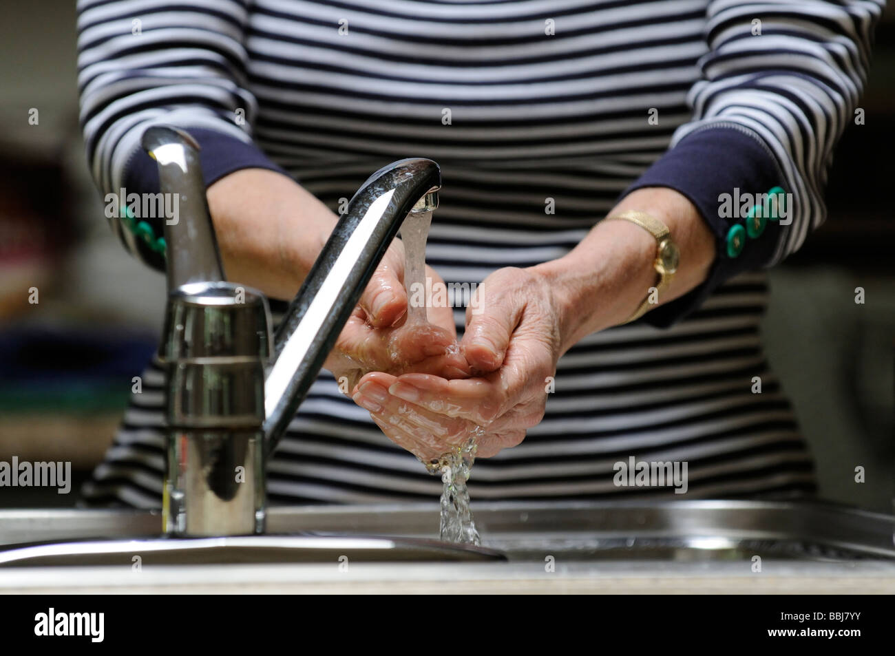 Woman washing hands under running water from the kitchen tap Stock ...