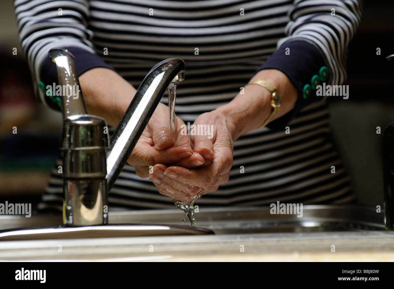 Woman washing hands under running water from the kitchen tap Stock ...