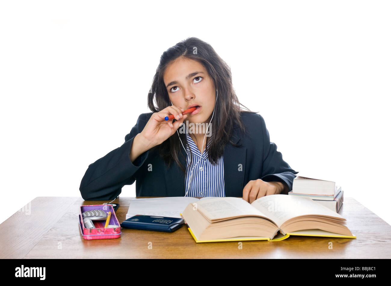 Horizontal portrait of a young school girl in her uniform chewing the ...