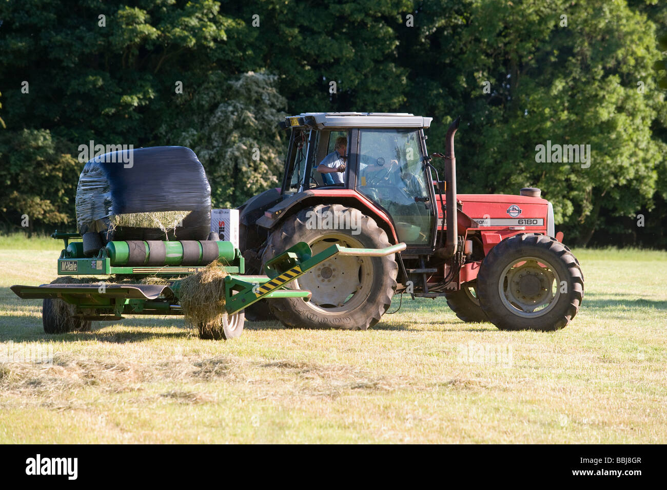 Tractor Wrapping Silage Bales Stock Photo - Alamy
