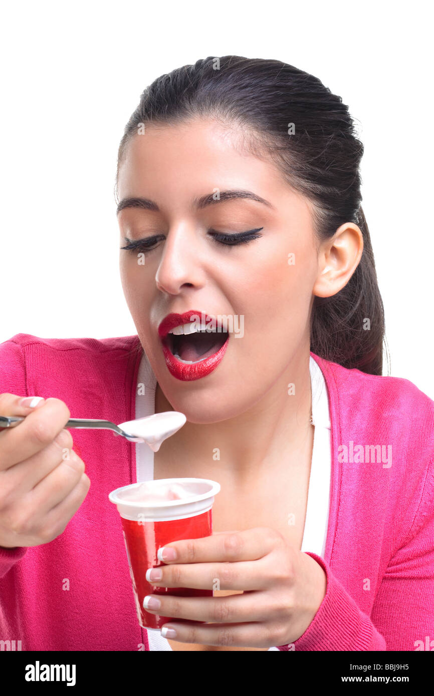 Young woman eating yoghurt isolated on a white background Stock Photo ...