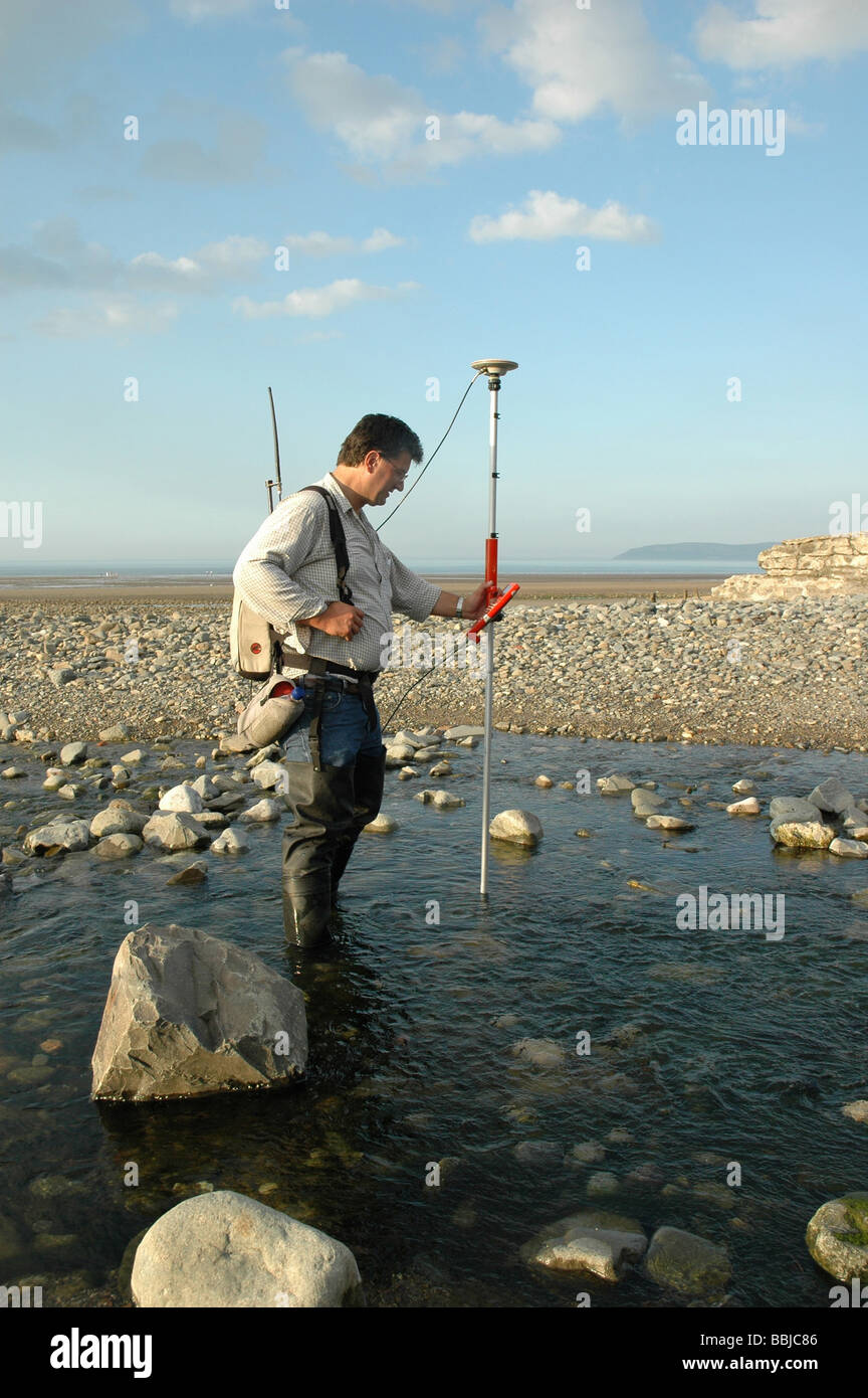 Hydrology technician undertaking river measurements at a small river as ...