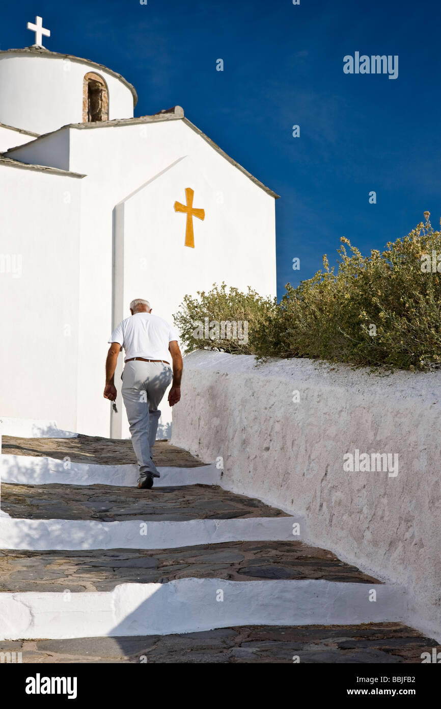 Greek man climbing steps towards church Skopelos Island The Sporades ...