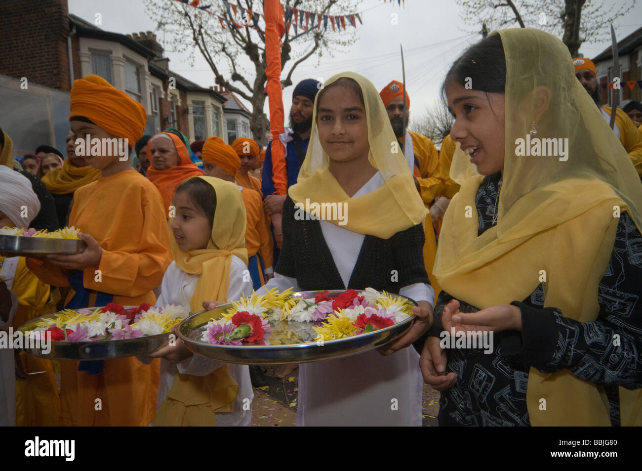 Young Sikhs carry flower garlands in trays outside the Gurdwara for the ...