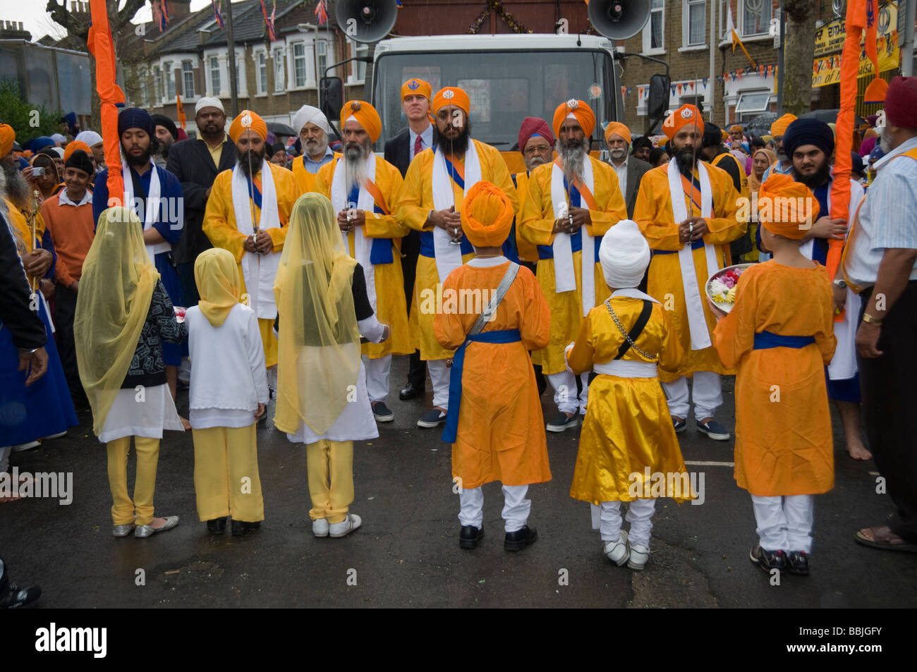 Young Sikhs bring flower garlands in trays for the Panj Piare (five ...