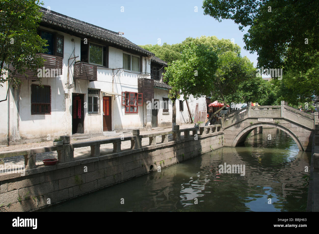 Houses and stone bridge over canal at the ancient water town of Tongli ...