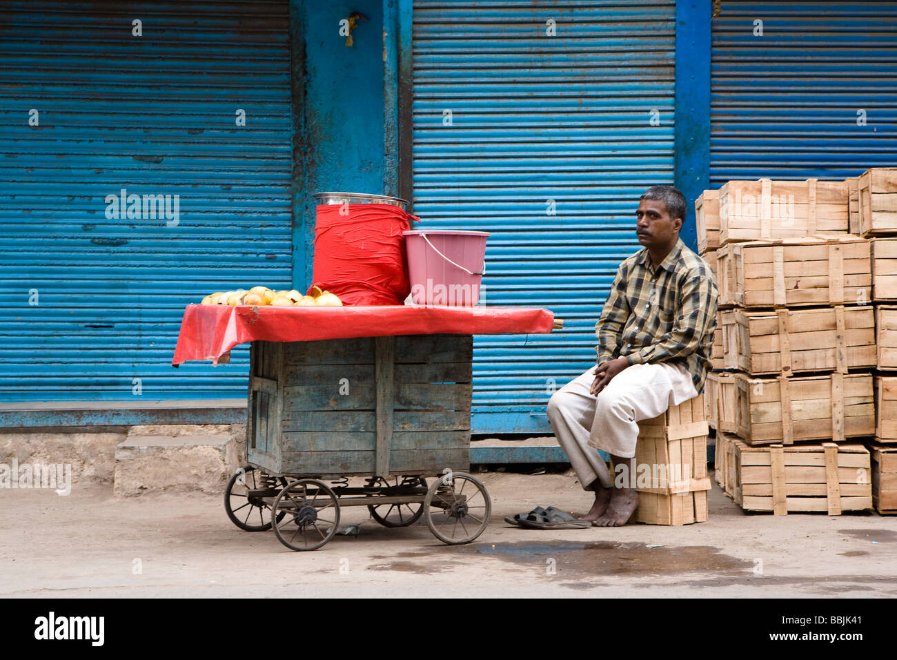 Man sitting on crate selling food from cart hi-res stock photography ...