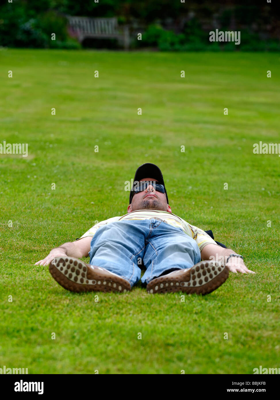 Man laying flat out on a lawn Stock Photo - Alamy