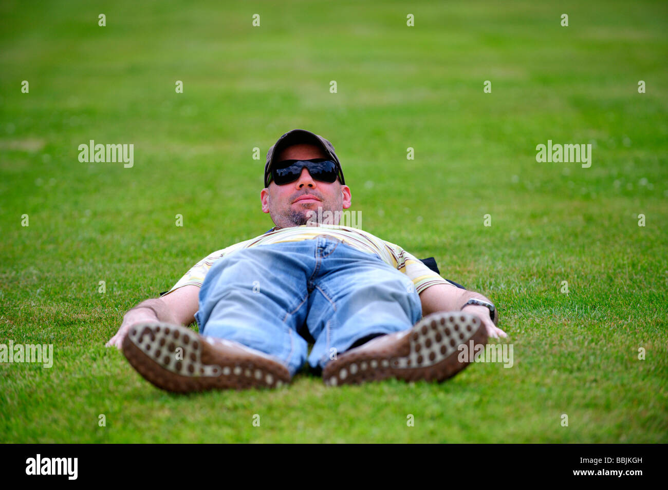 Man laying flat out on a lawn Stock Photo - Alamy