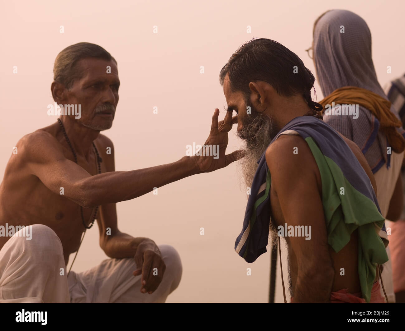 Man anointing forehead of another man in India Stock Photo - Alamy